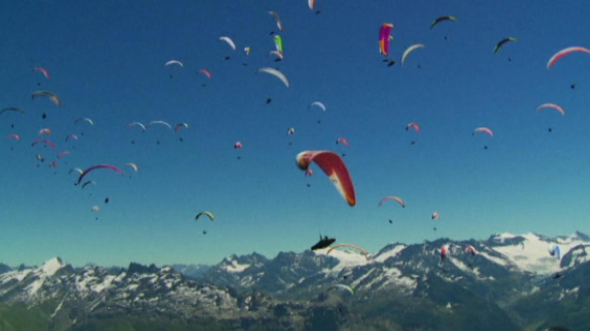 Wolk van paragliders in de lucht