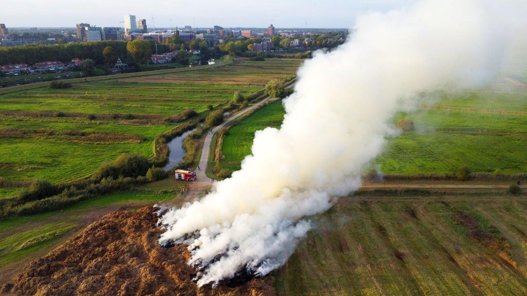 Berg hooi in brand, stinkende rook boven Den Bosch